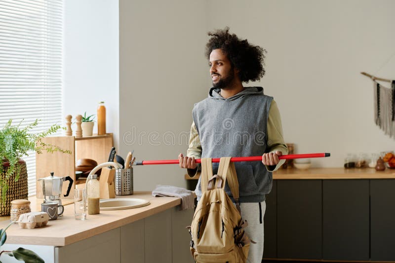 Happy Guy Lifting Backpack on Stick Stock Photo - Image of ...