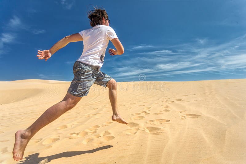 Happy guy running on sand stock photo. Image of sand - 89358706