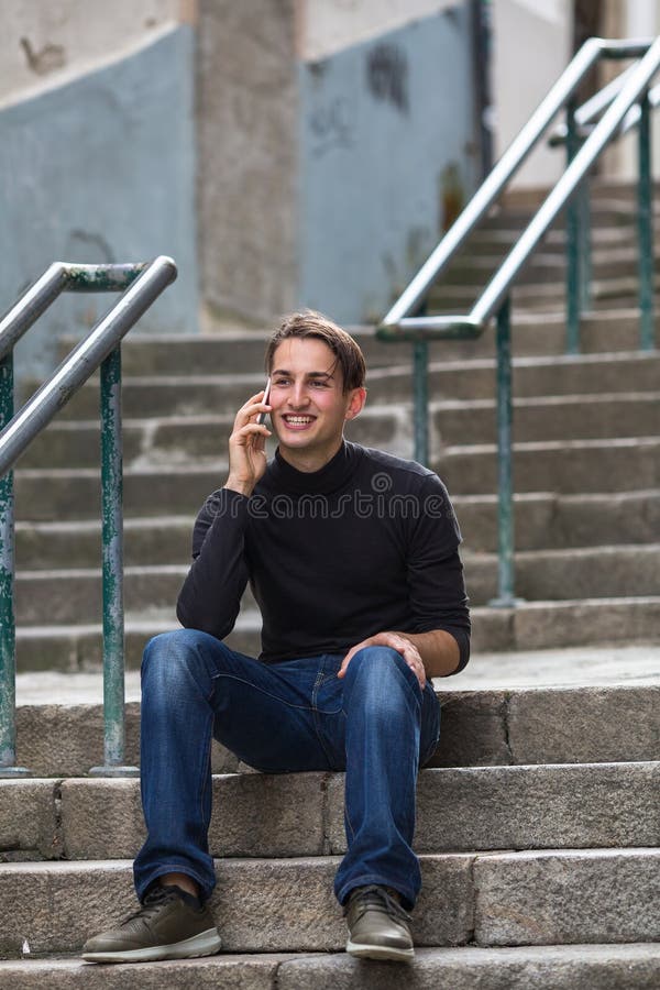Happy Guy Sitting on the Street Steps Talking on a Mobile Phone. Stock ...