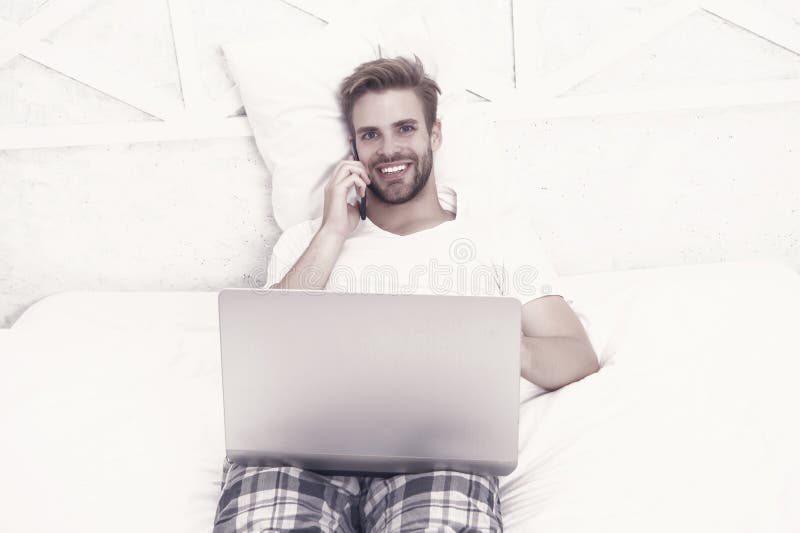 Happy Guy Talk on Phone Using Laptop Computer Technology in Bed ...