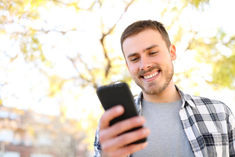 Happy Guy Uses a Smart Phone in a Park Stock Image - Image of game ...