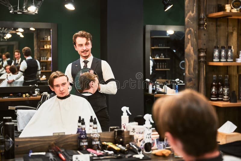 Happy Hairdresser Showing New Haircut To His Client. Stock Photo ... Happy Hairdresser Showing New Haircut To His Client. Stock Photo ...