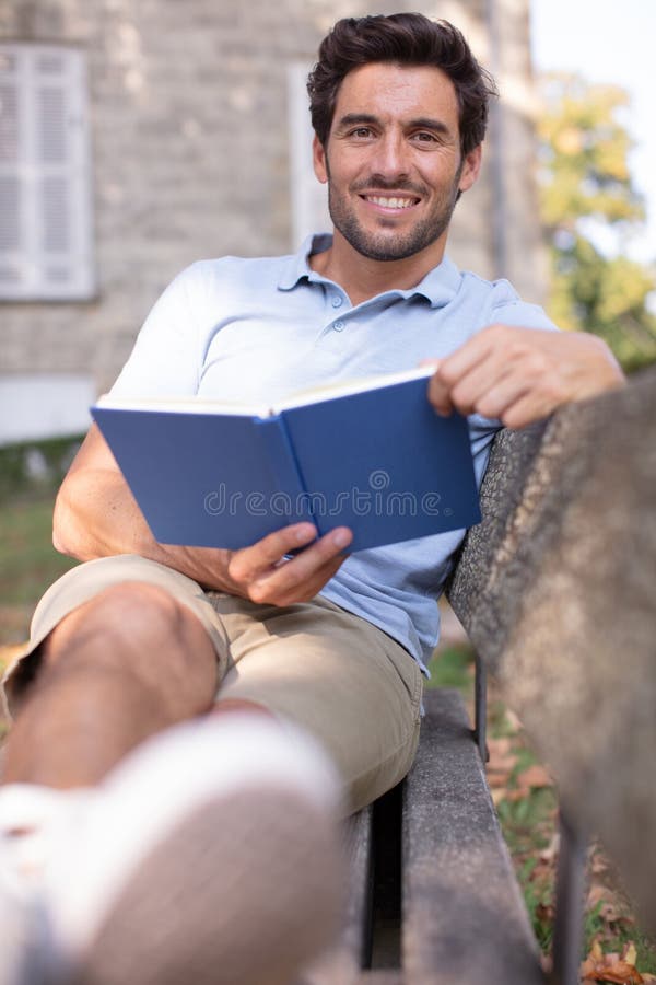 Happy Handsome Man Reading Book Outdoors Stock Image - Image of ...