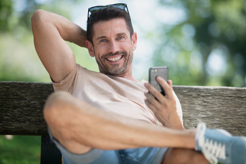 Happy Handsome Man Sitting on Bench Outdoors Stock Image - Image of ...