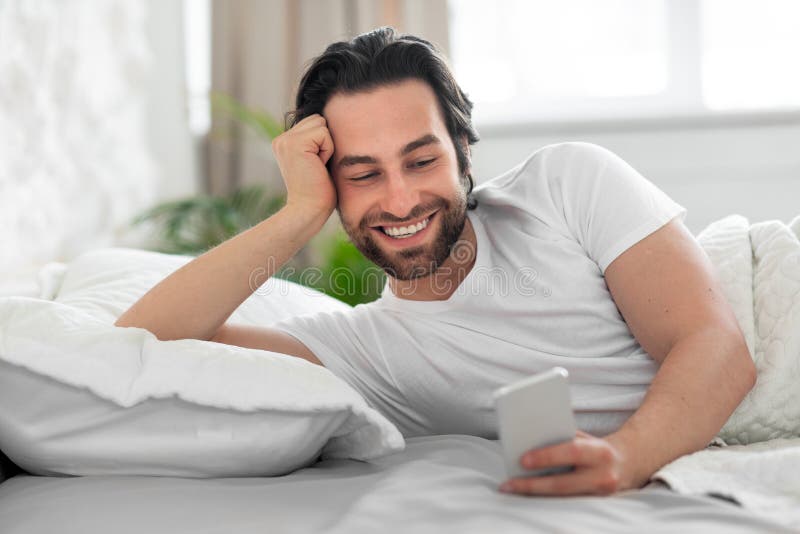 Happy Millennial Man Using Cell Phone after Waking Up Stock Image ...