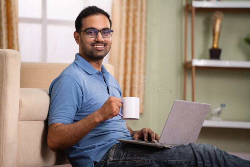 Happy Indian Man Using Laptop by Drinking Coffee or Tea by Looking at ...
