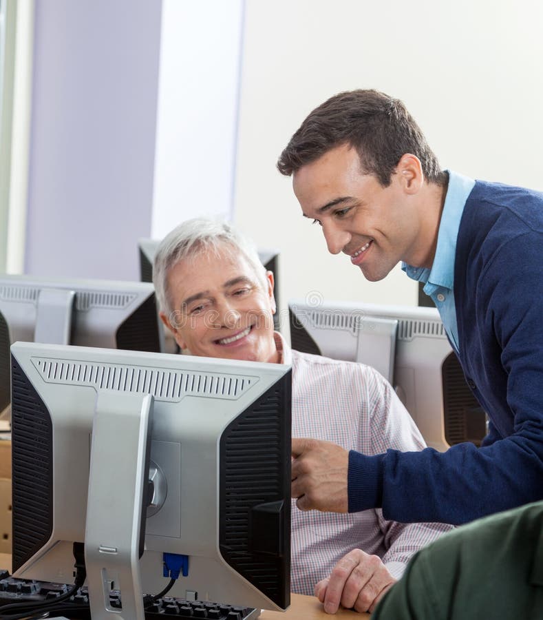Happy Instructor Assisting Senior Man at Computer Desk Stock Image ...