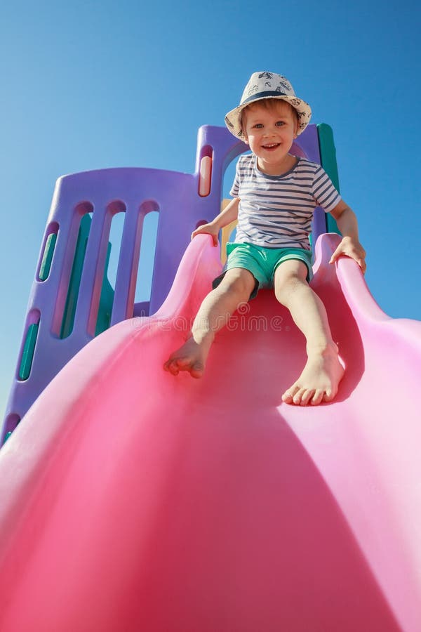 Happy Kid Playing Slide at the Playground Under the Sunlight in Summer ...