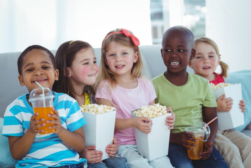 Happy Kids Enjoying Popcorn and Drinks while Sitting Stock Photo ...