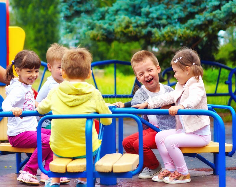 Happy Kids Having Fun on Roundabout at Playground Stock Photo - Image ...