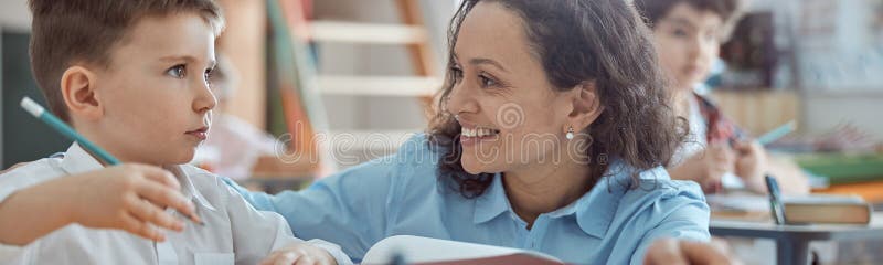 Happy Kind Teacher is Helping Kids in Elementary School Lessons Stock ...