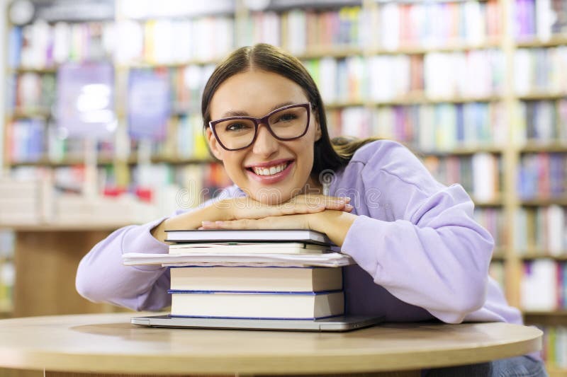 Happy Lady Student in Glasses Sitting at Desk with Stack of Books in ...