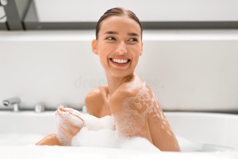 Happy Lady Taking Bath Relaxing Sitting In Bathtub In Bathroom Stock