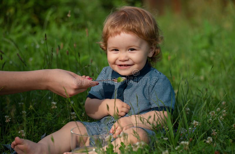 Happy Little Baby is Being Fed Using Spoon. Spoon Feeding Baby. Stock ...