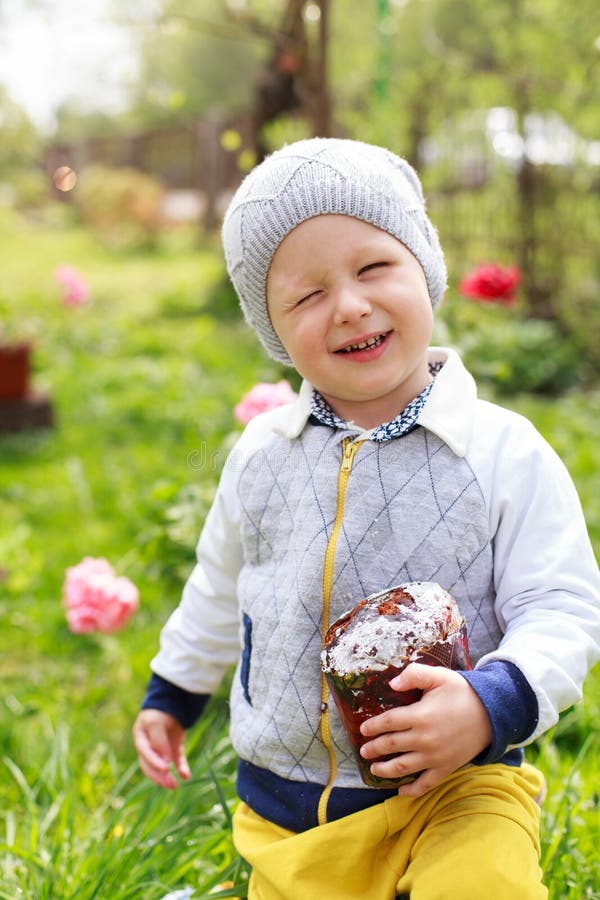 Happy Little Boy Eats Easter Cake, in Spring Garden, Outside. Cute ...
