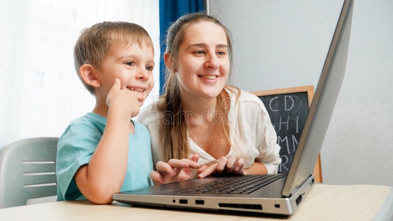 Happy Little Boy with Mother Smiling and Looking on Laptop Screen ...
