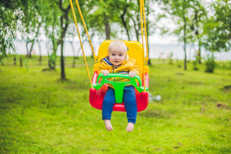 Happy Little Boy Riding on a Swing in a Park Stock Photo - Image of ...