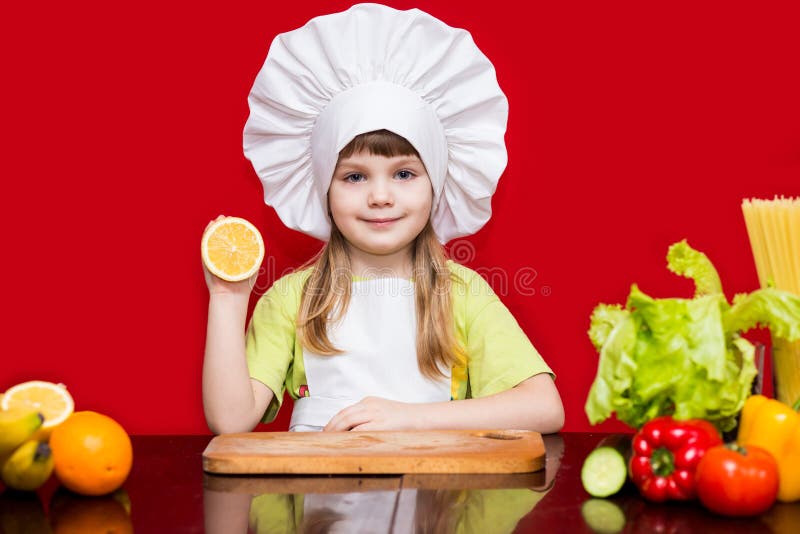 Happy Little Girl in Chef Uniform Cuts Fruit in Kitchen Stock Image ...