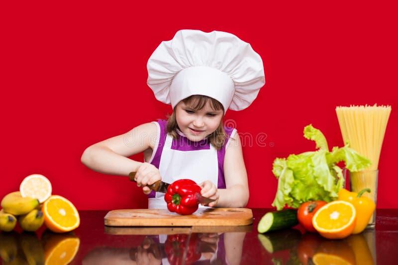 Happy Little Girl in Chef Uniform Cuts Vegetables in Kitchen Stock ...