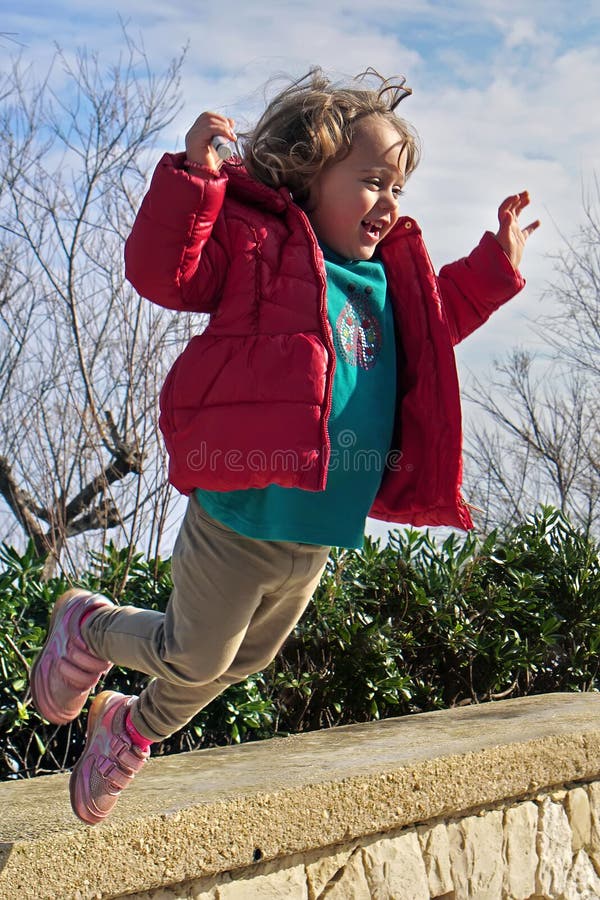 Happy Little Girl Jumping and Smiling Stock Photo - Image of beautiful ...