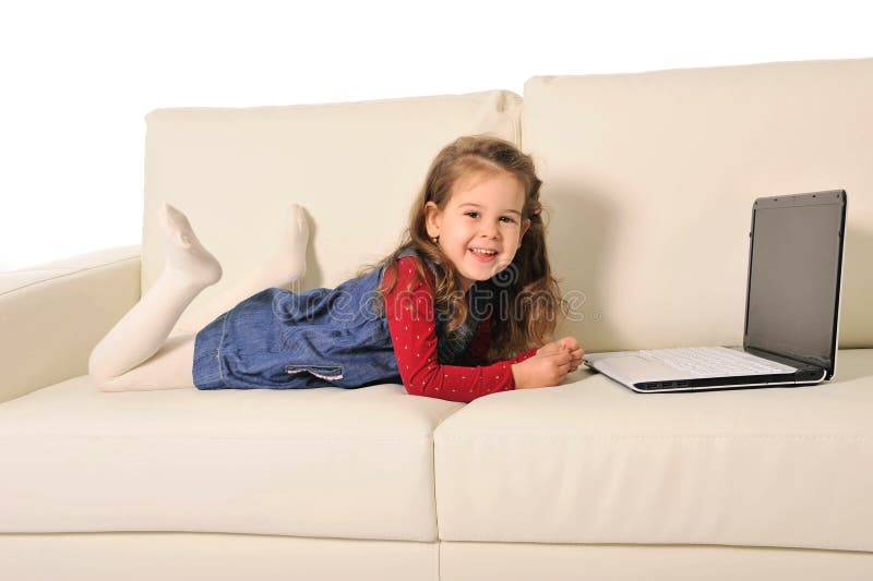 Happy Little Girl Lying on Couch Playing with Computer Stock Photo ...