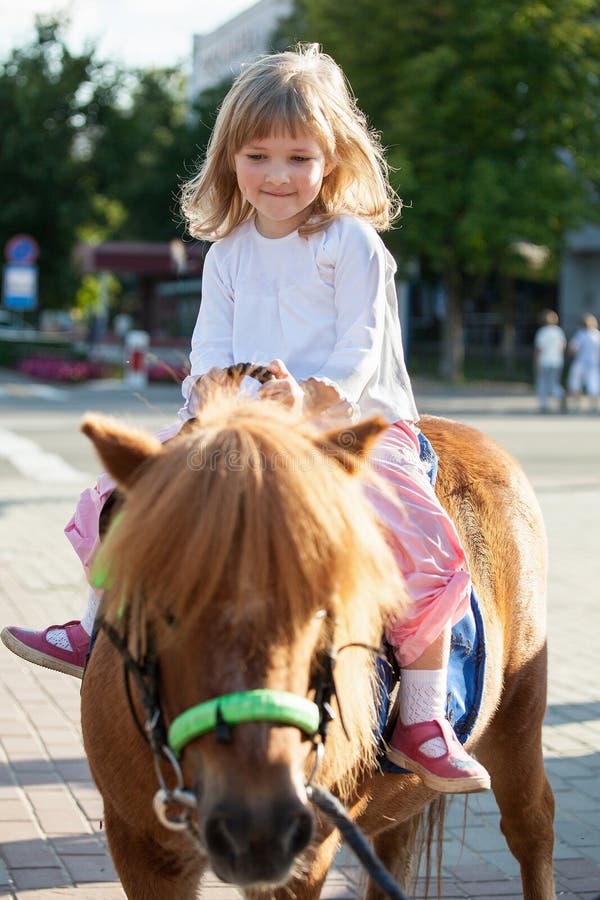 Little Girl Riding on a Pony in a City Park Stock Photo - Image of ...