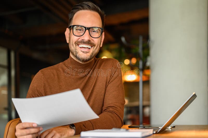 Happy Male Project Manager with Document and Laptop at Desk Looking at ...
