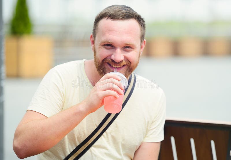 Happy Man with a Beard Drinking a Soft Drink in the City Smiling. Stock ...