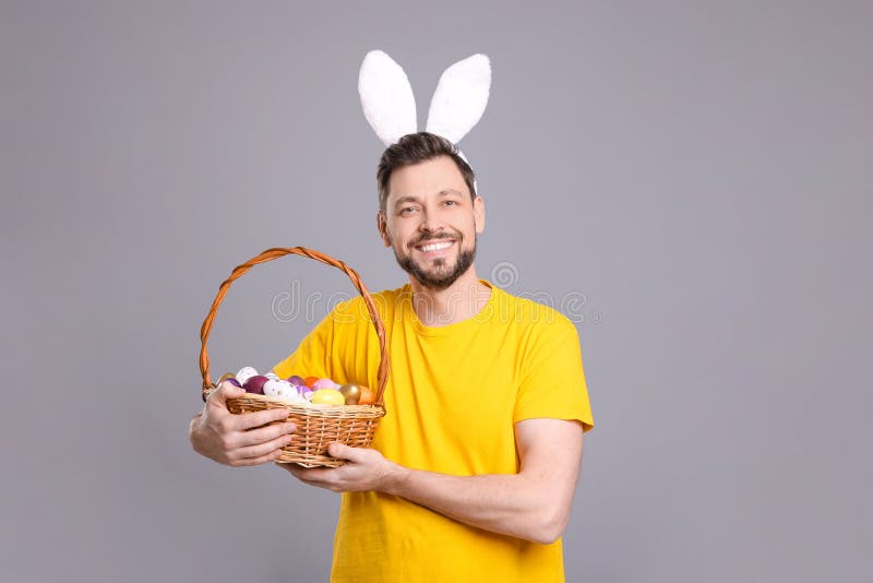 Happy Man in Bunny Ears Headband Holding Wicker Basket with Painted ...