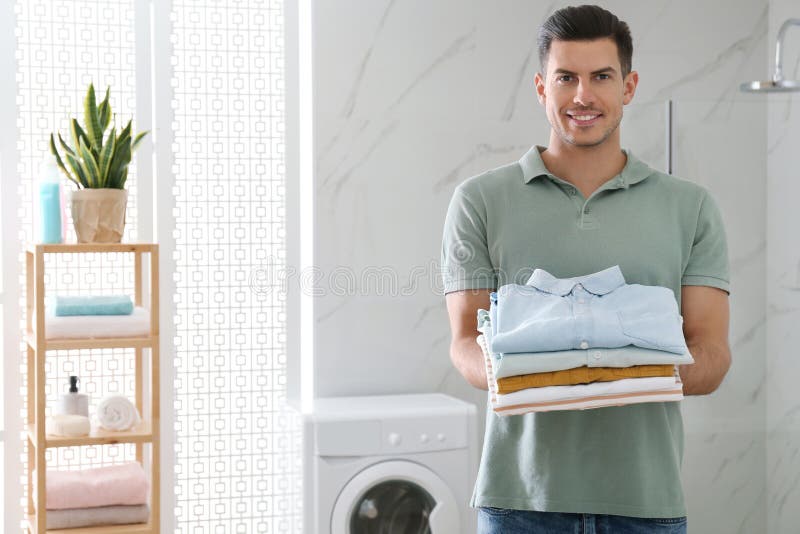 Happy Man with Clean Clothes in Bathroom. Laundry Day Stock Image ...