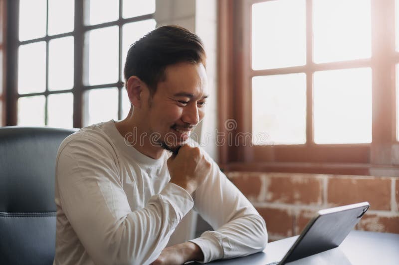 Happy Man Doing Work Online from His Tablet in His Own Office. Stock ...