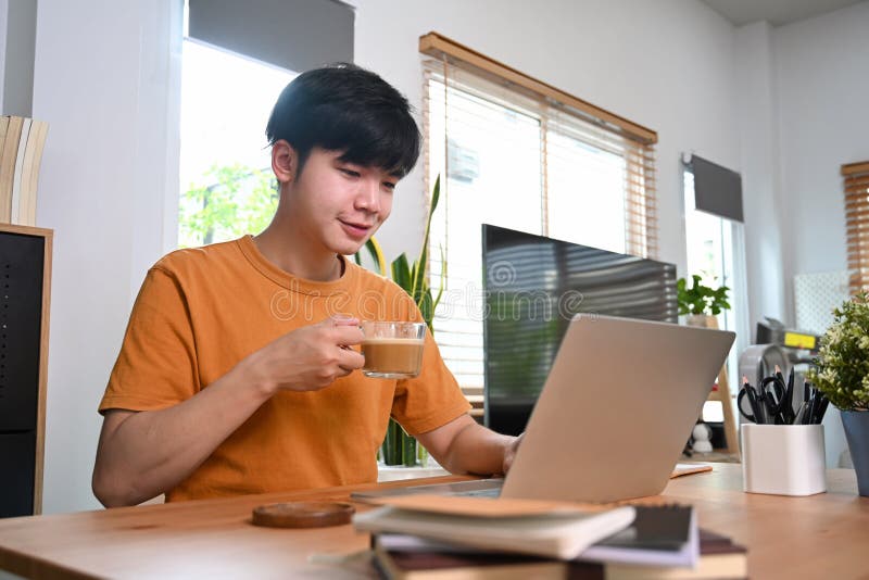 Man Drinking Coffee and Using Laptop Computer at Home in the Morning ...