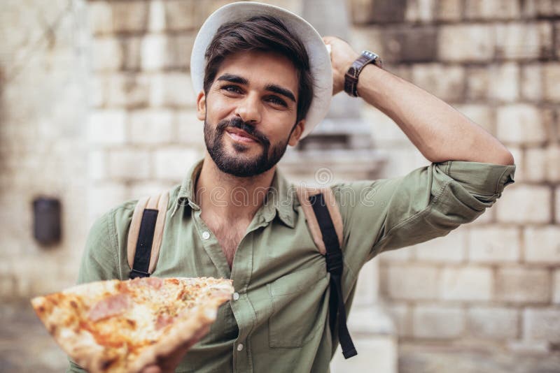 Man eating pizza on street stock image. Image of food - 168700687