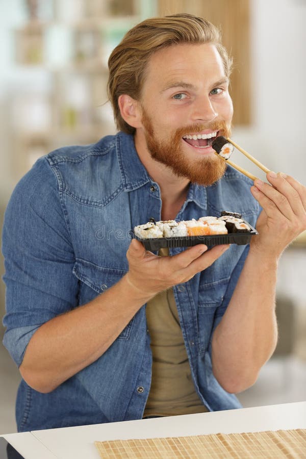 Happy man eating sushi stock photo. Image of glad, food - 218239748