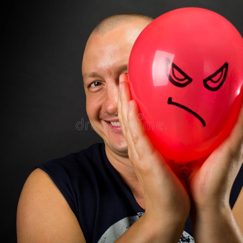 Happy Man Hiding Behind Angry Balloon Stock Photo - Image of furious ...
