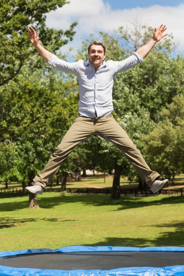 Happy Man Jumping High on Trampoline in Park Stock Photo - Image of ...