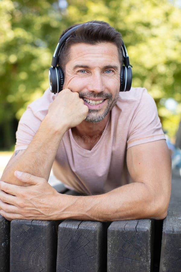 Happy Man Listening To Music on Bench Outdoors Stock Image - Image of ...