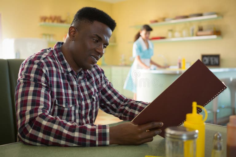 Man Looking at Menu in Restaurant Stock Image - Image of female ...