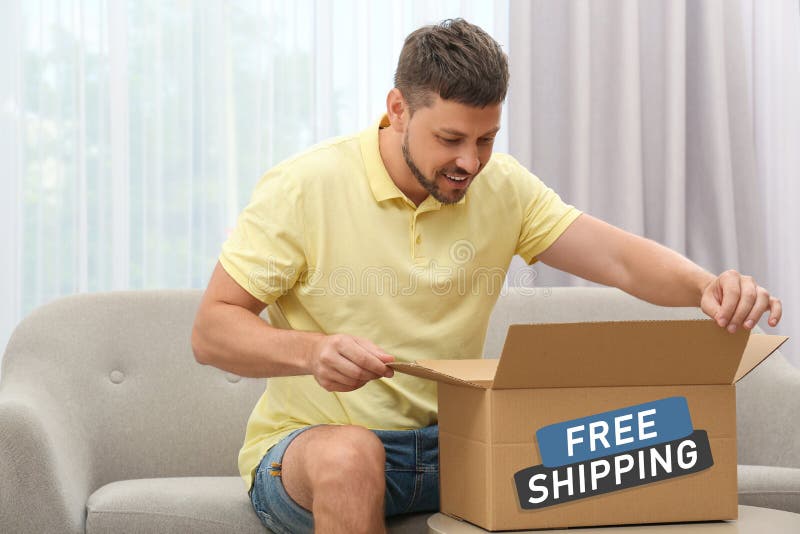 Happy Man Opening Parcel on Sofa at Home. Free Shipping Stock Image ...