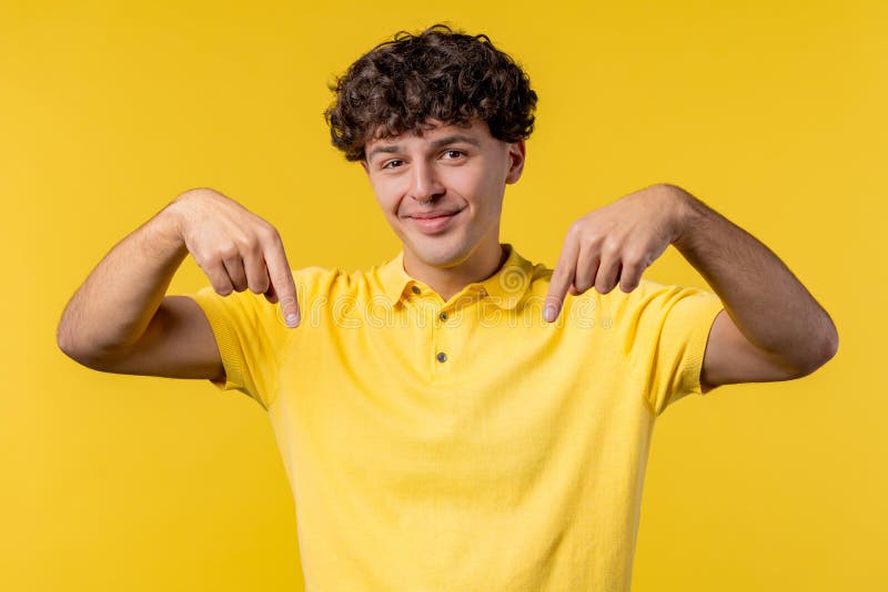 Happy Man Pointing Down To Advertising Area Yellow Background Young