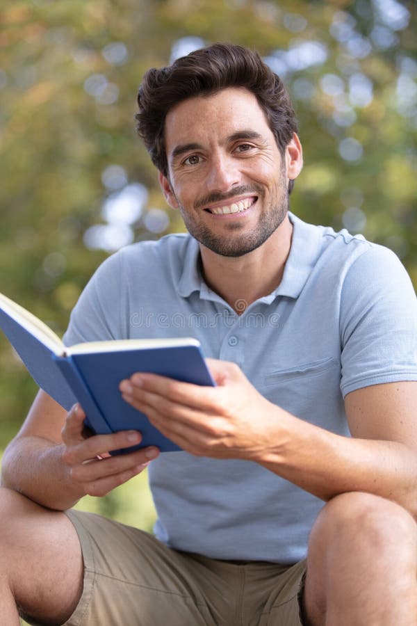 Happy Man Reading Book Outside in Park Stock Image - Image of holding ...