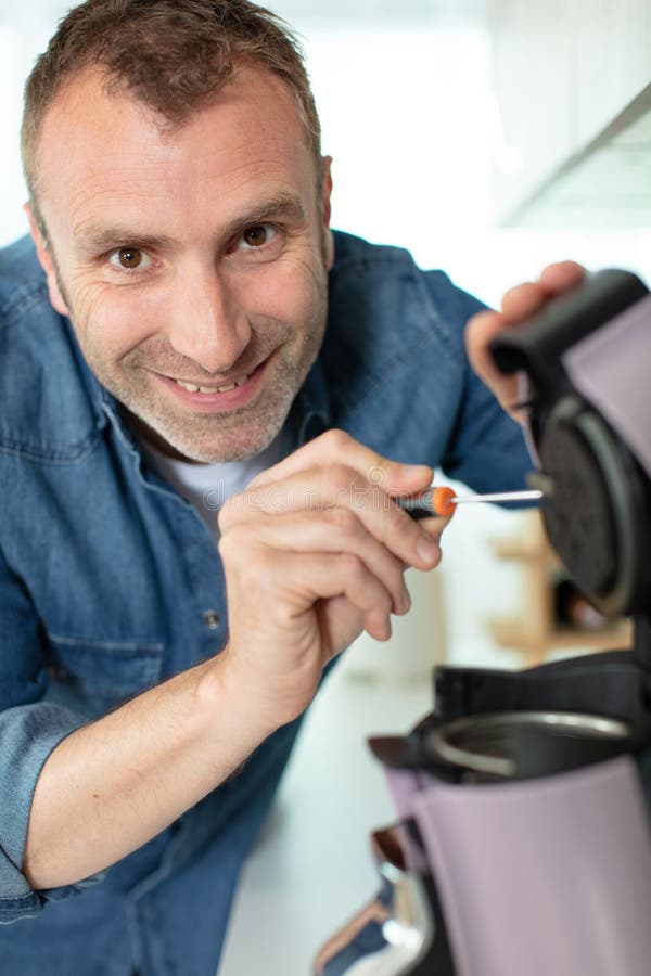 Happy Man Repairing Coffee Machine in Kitchen Stock Photo - Image of ...