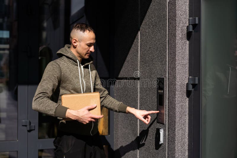 Happy Man Ringing Intercom with Camera in Entryway. Stock Photo - Image ...