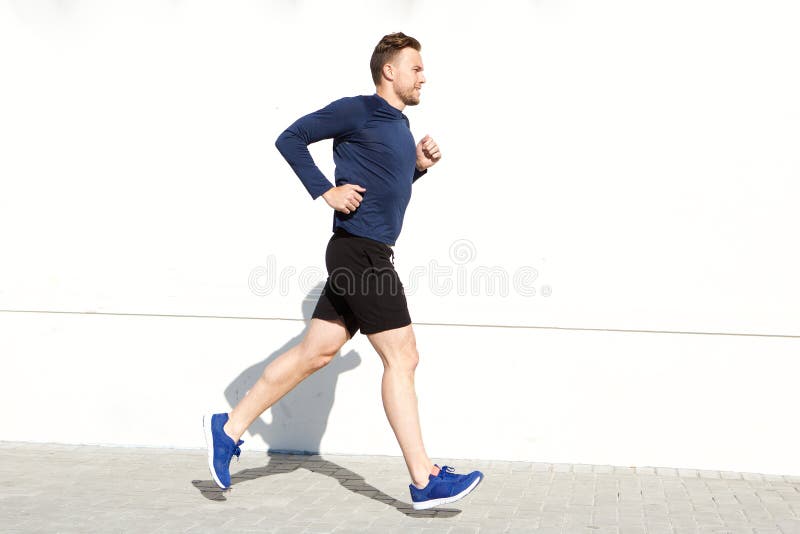 Happy Man Running Outside Against White Wall Stock Photo - Image of ...