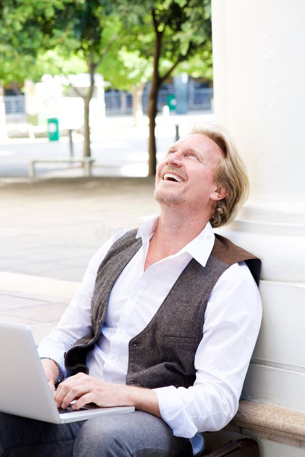 Happy Man Sitting Outdoors with Laptop and Laughing Stock Photo - Image ...