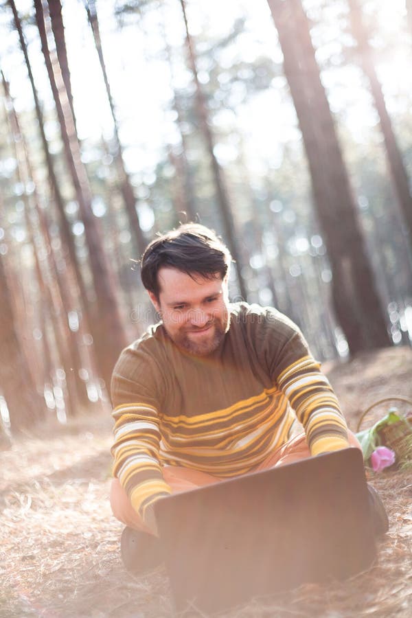 Happy Man Sitting Outdoors Using a Laptop Computer Stock Image - Image ...