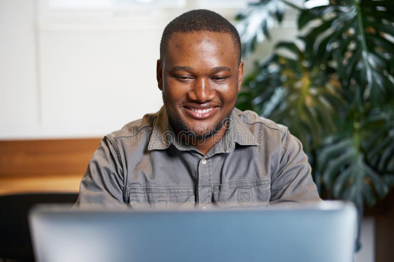 Happy Man Smiling while Using a Laptop in a Bright and Cheerful ...