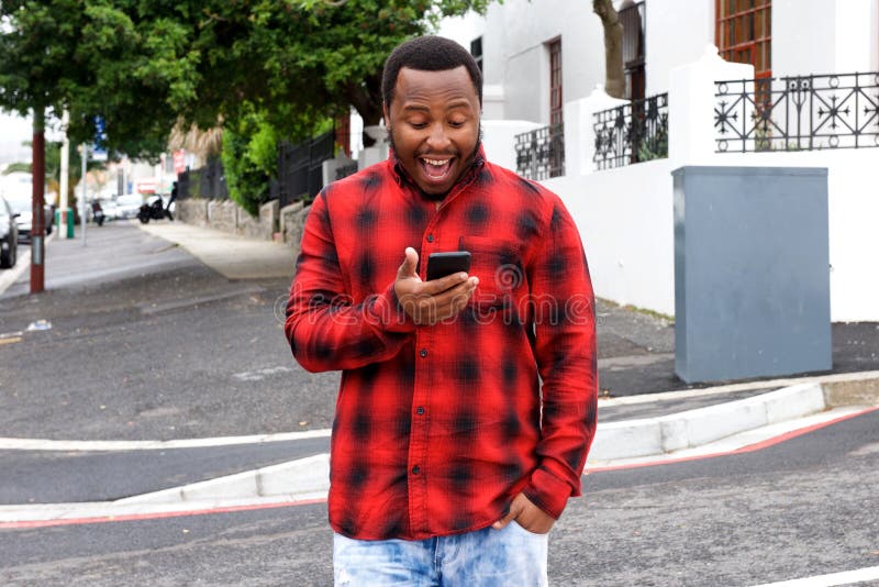 Happy Man Standing Outside and Looking at Mobile Phone Stock Image ...