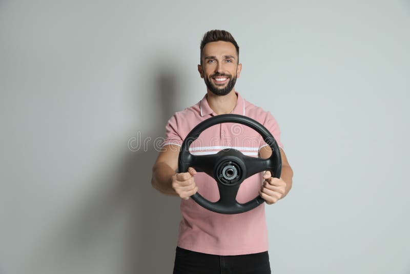 Happy Man with Steering Wheel on Grey Background Stock Image - Image of ...
