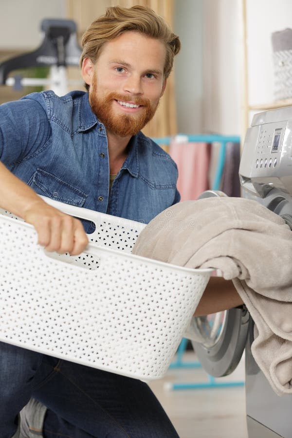 Happy Man Taking Clothes from Drying Machine Stock Photo - Image of ...
